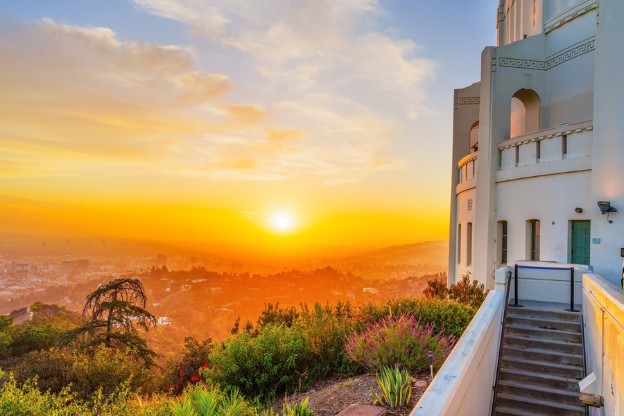 Um pôr do sol sobre uma paisagem urbana com um edifício de arquitetura clássica.