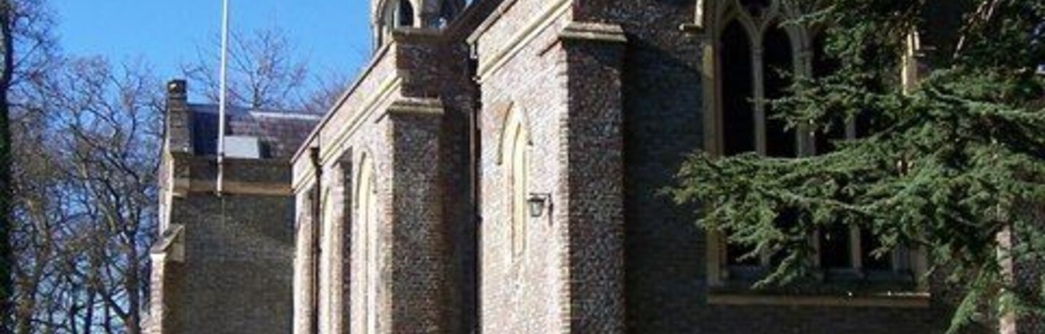 Igreja com uma torre alta e cemitério à frente.