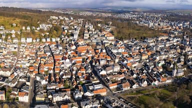 Vista aérea de uma cidade densamente povoada, com diversos edifícios residenciais e uma torre de igreja imponente.