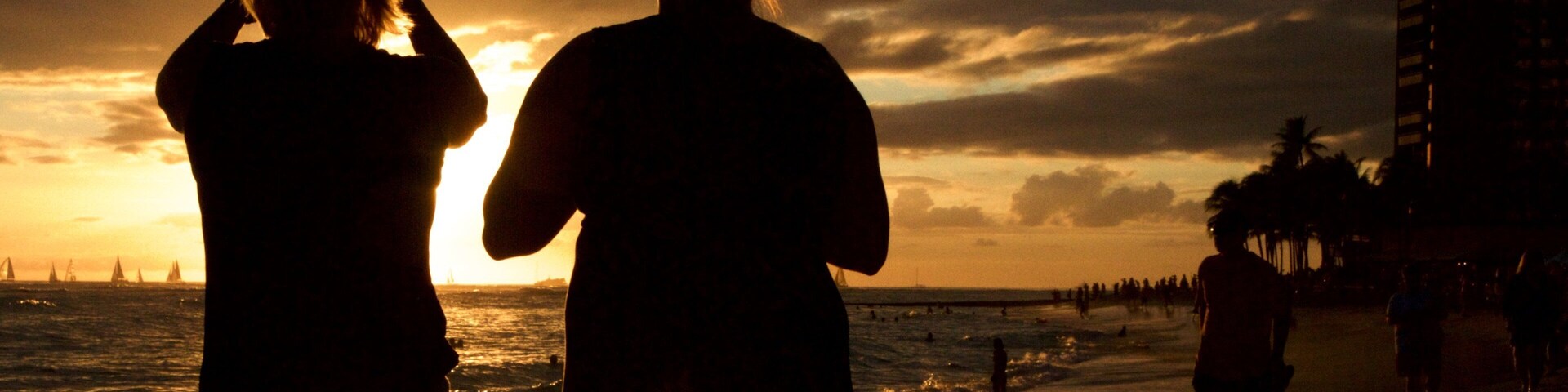 Waikiki Beach mostrando um pôr do sol, uma praia de areia e paisagens litorâneas