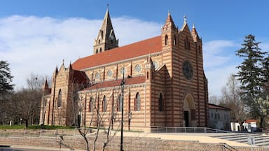 Uma igreja grande de tijolos com telhado vermelho e várias torres.