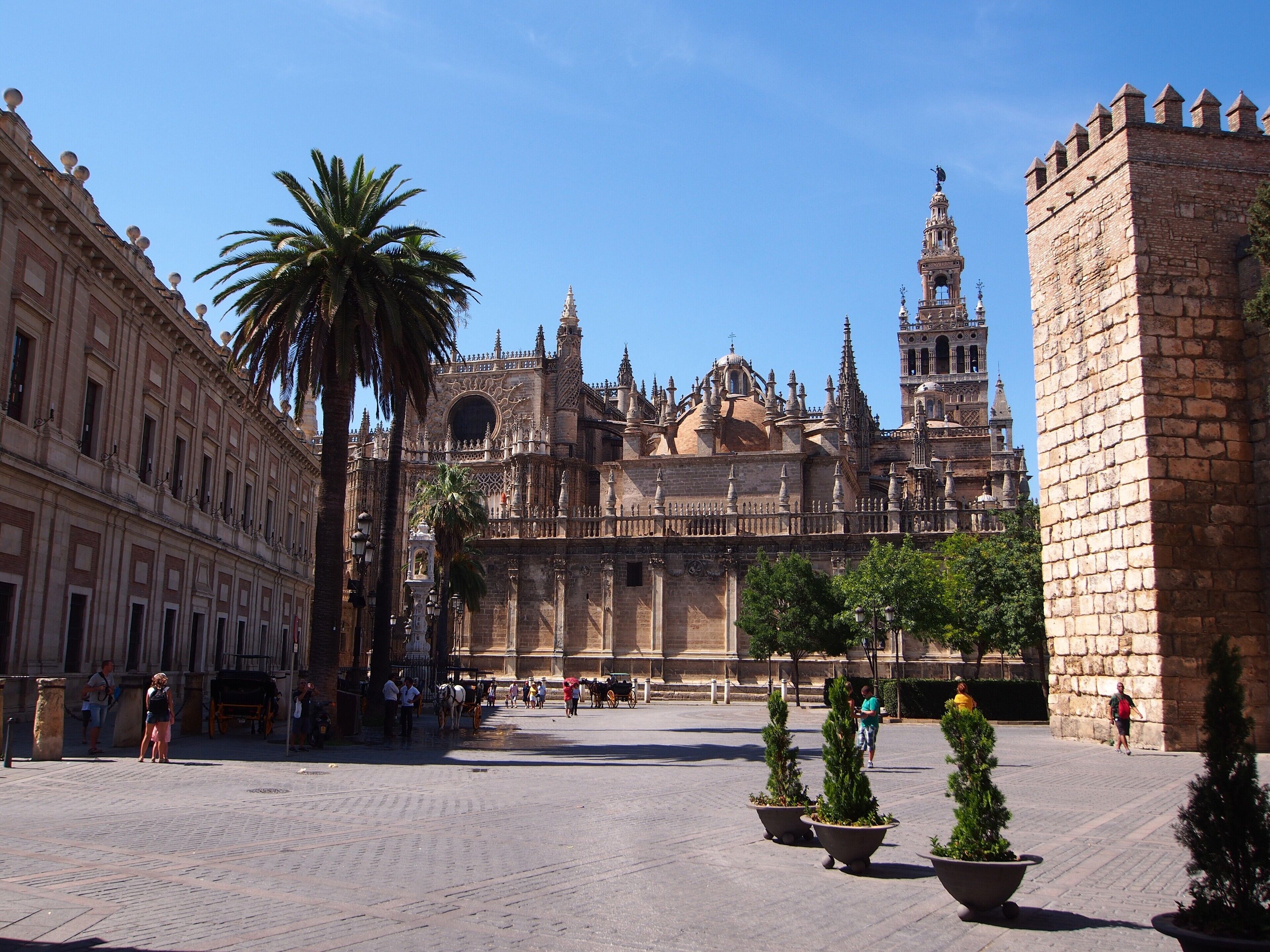 Uma praça histórica com uma catedral imponente, com torres ornamentadas e um campanário.