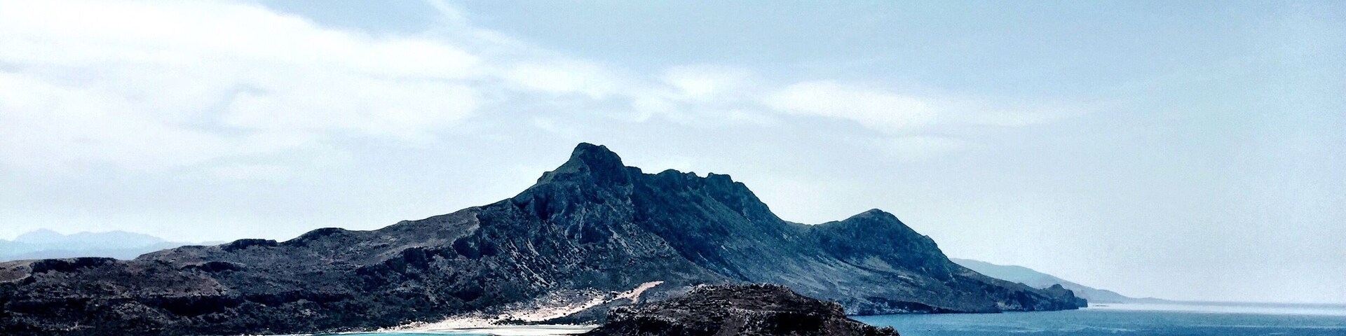 Uma ilha montanhosa cercada por águas azul-claras.