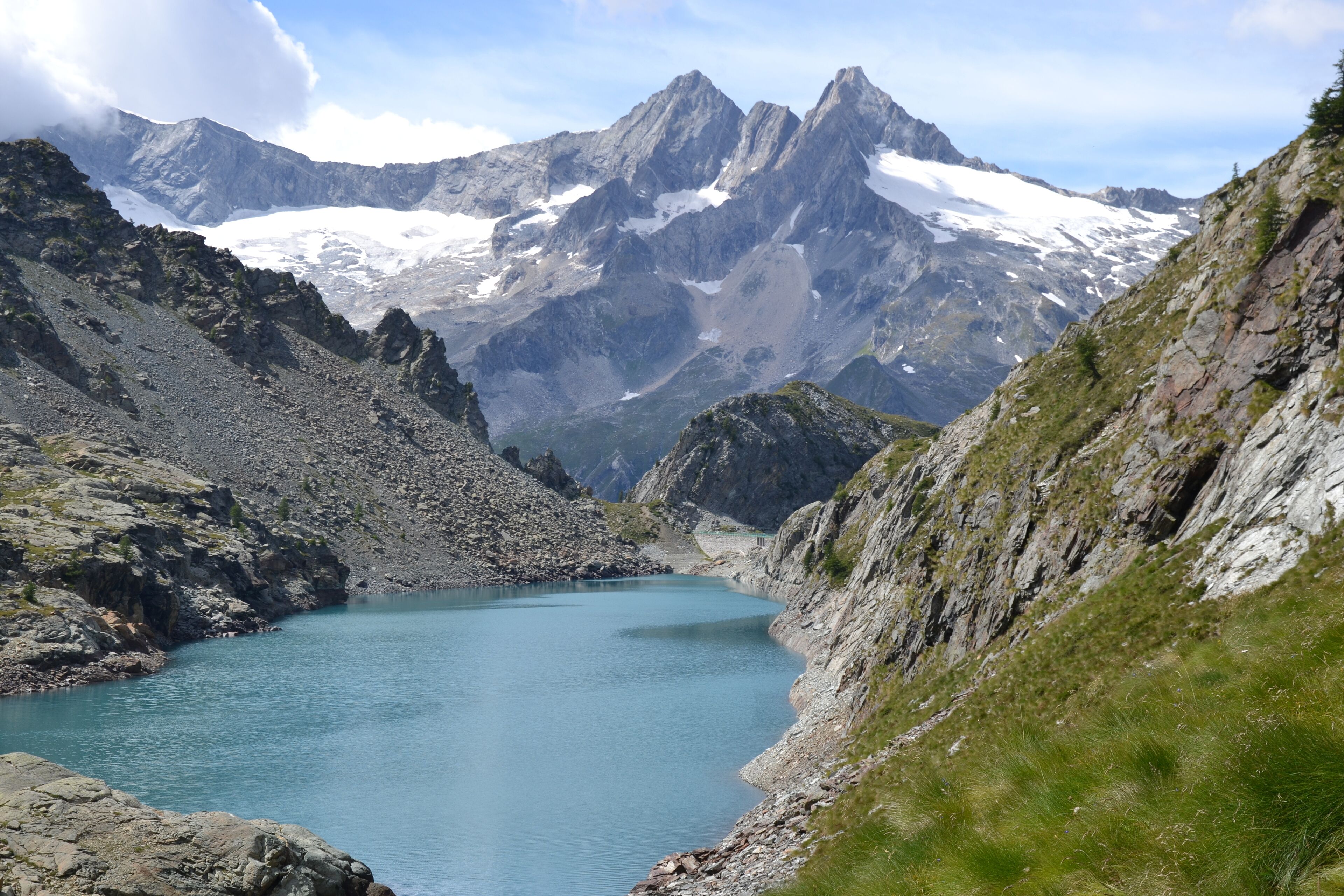 Um lago montanhoso rodeado por picos acidentados e montanhas nevadas.