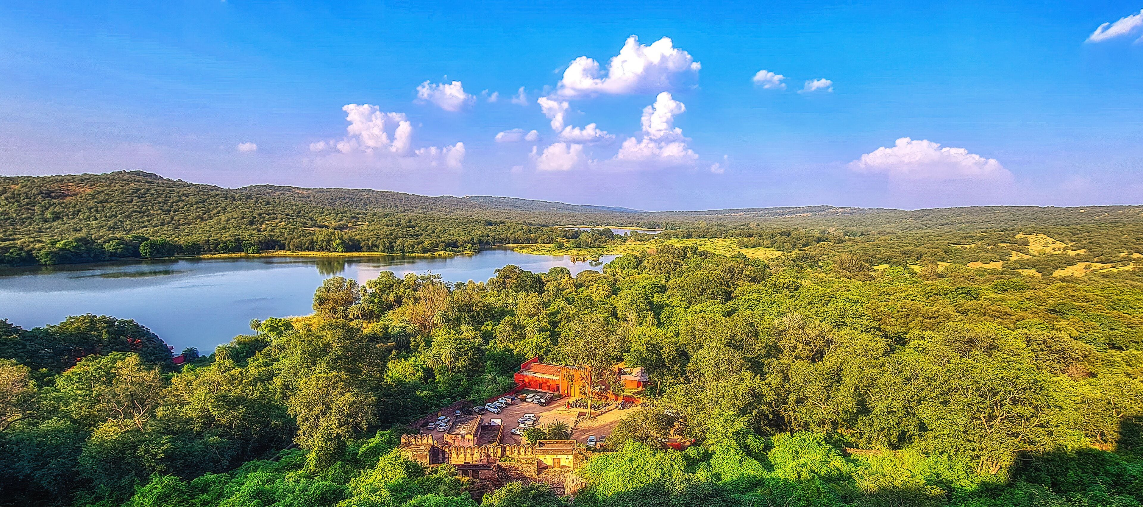 Um lago rodeado por uma floresta densa e colinas.