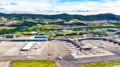Um aeroporto rodeado por montanhas e uma cidade.