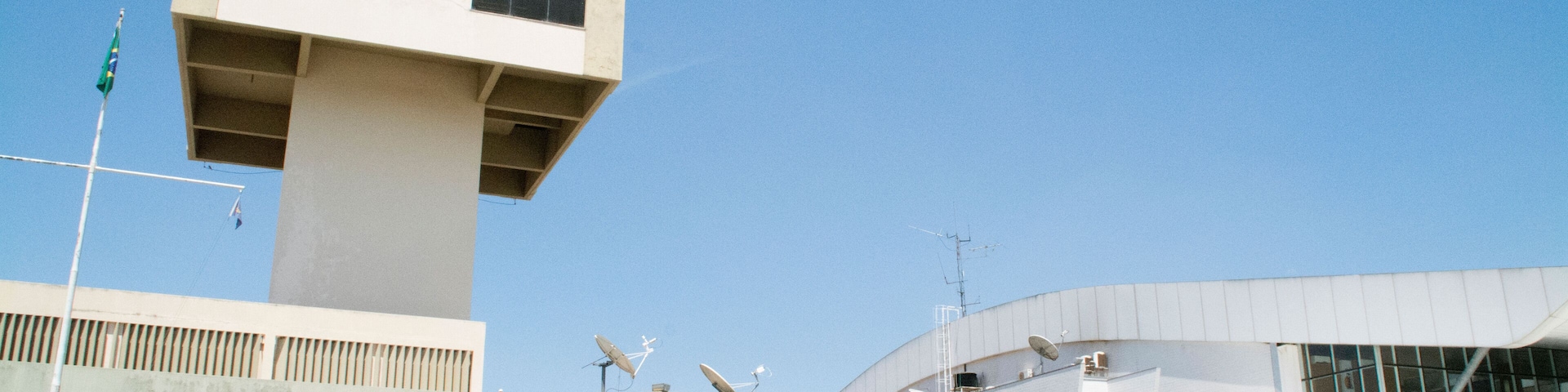 A control tower, a yellow truck, and a building with the sign "DTCEA CUIABA".