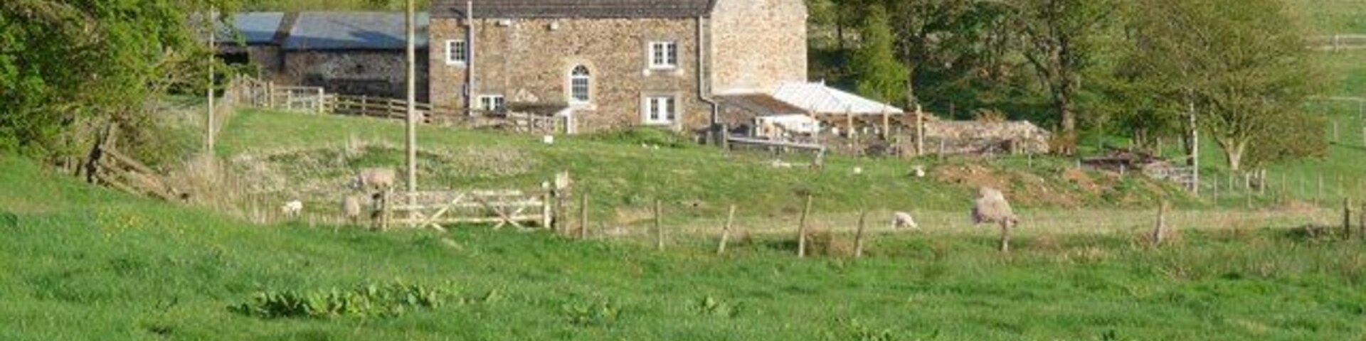 Uma casa de pedra com telhado inclinado em um cenário rural.
