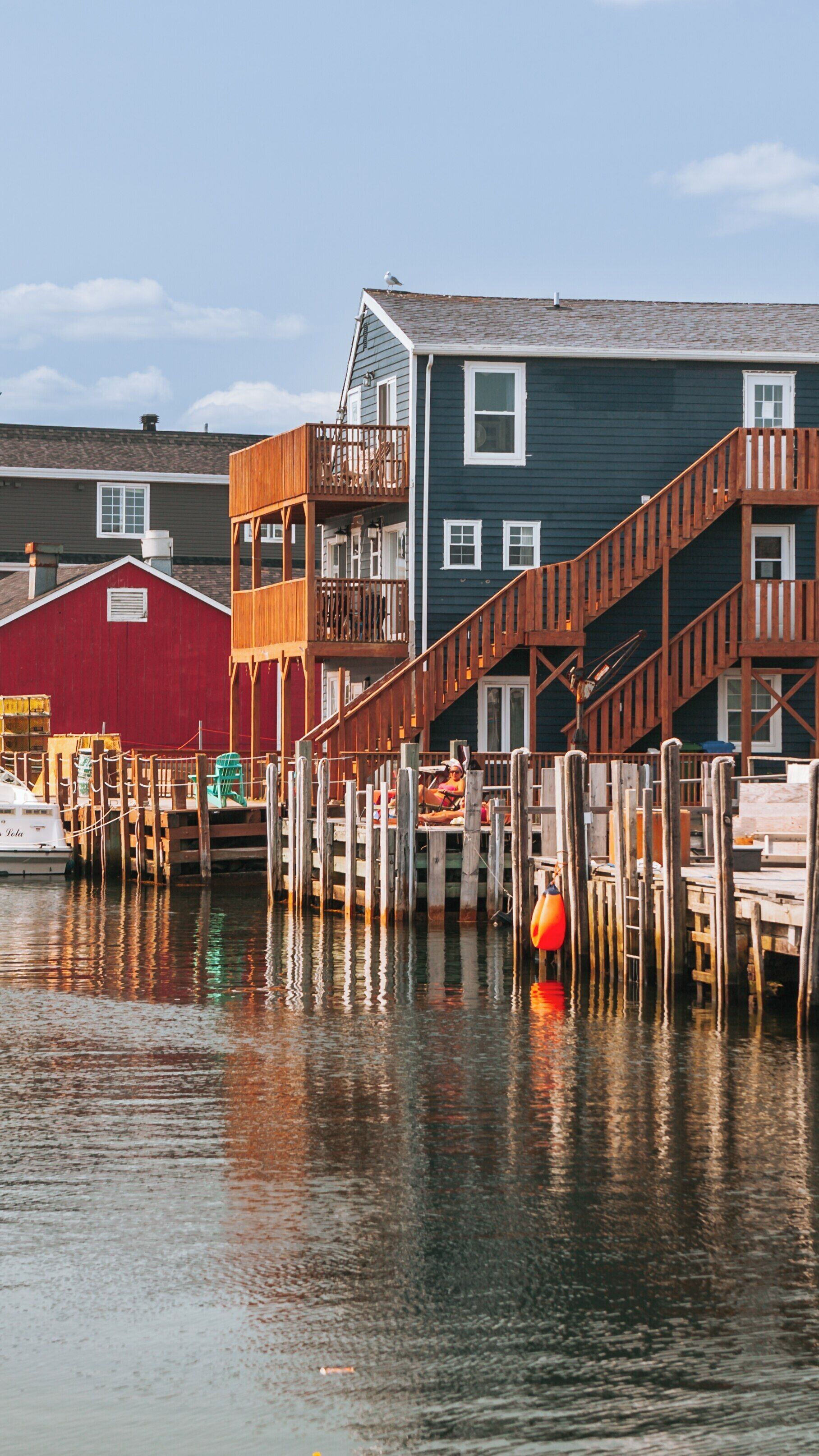 Colorful buildings and tranquil waters at Fisherman's Cove in Dartmouth, Nova Scotia reflect coastal charm in a serene afternoon