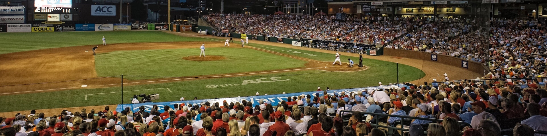 Greensboro featuring a sporting event and night scenes as well as a large group of people