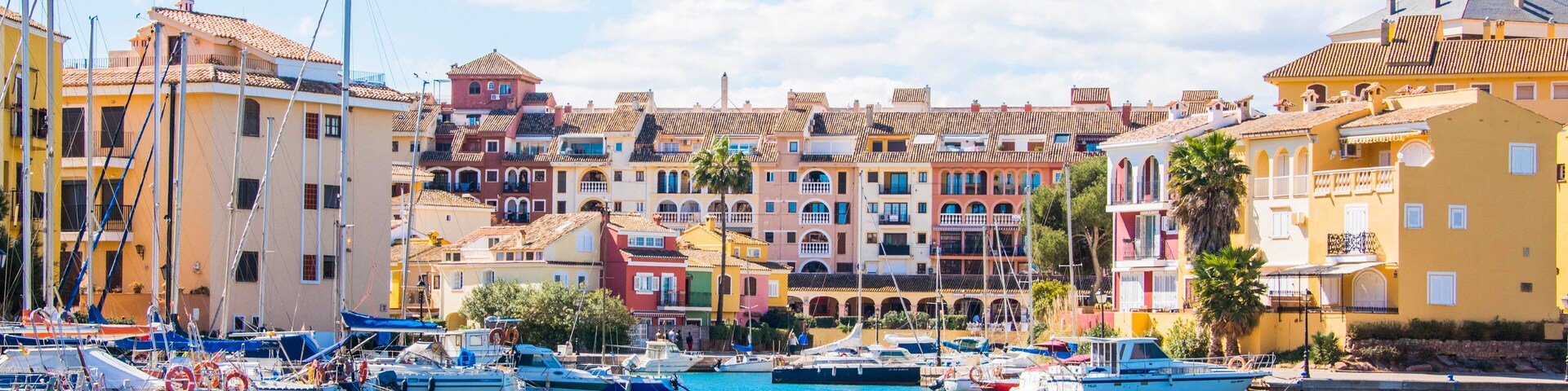 Uma marina com edifícios coloridos e barcos atracados.
