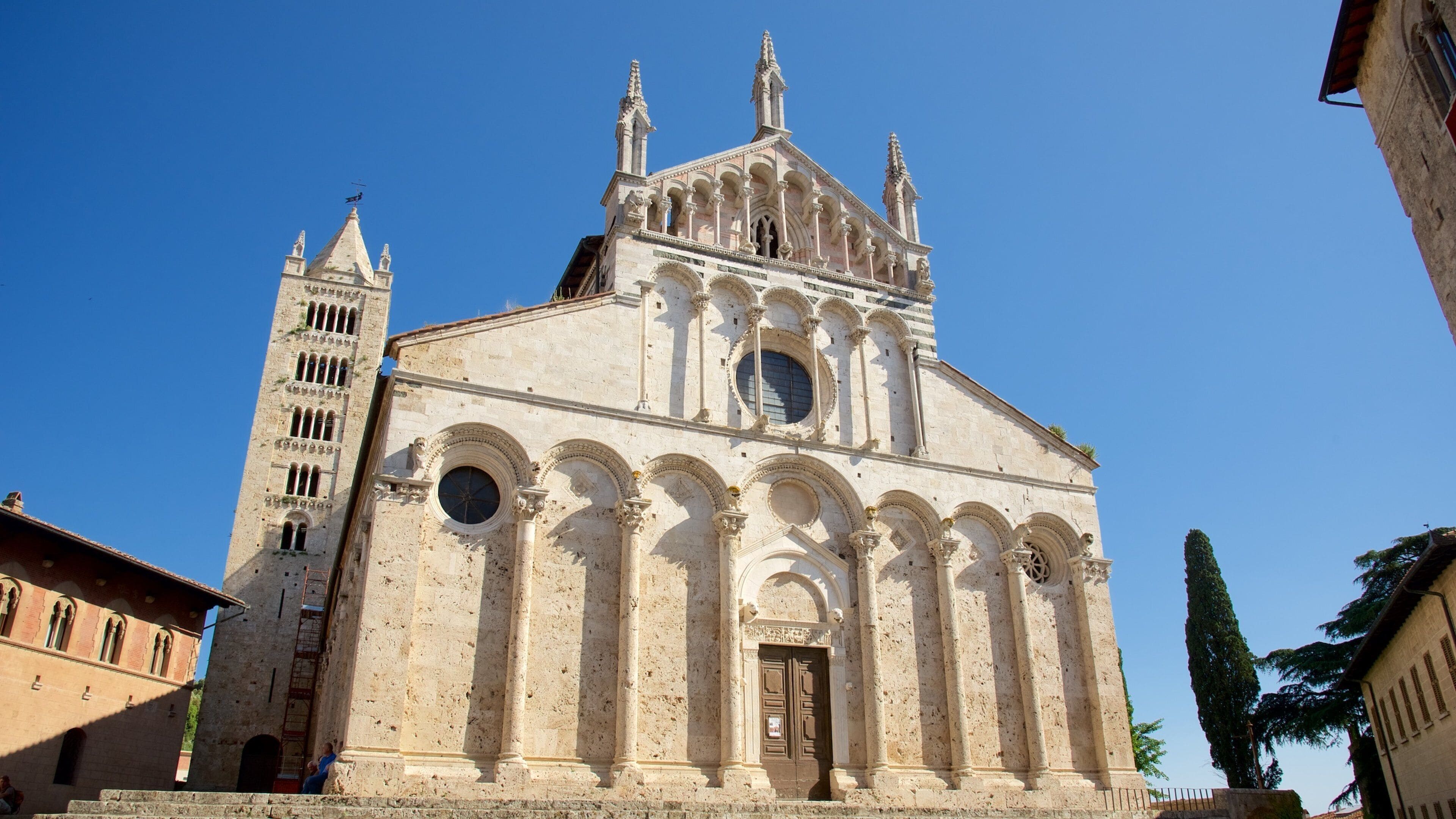 Uma catedral histórica com uma alta torre de sino e uma grande cúpula central.