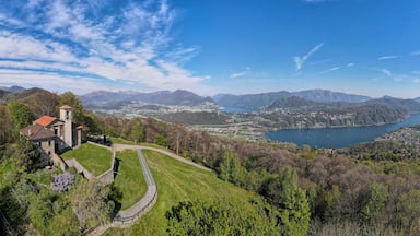Paisagem montanhosa com um lago, uma igreja e uma cidade.