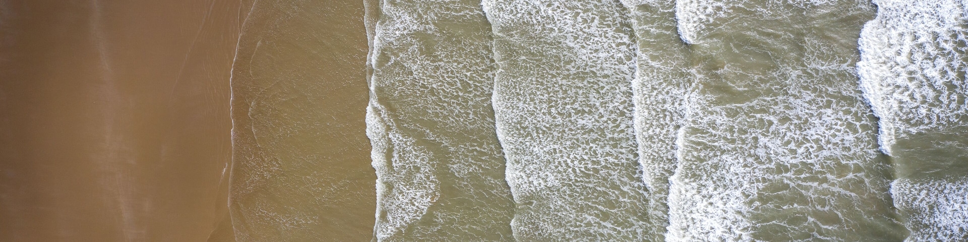 Uma praia com ondas quebrando na costa.