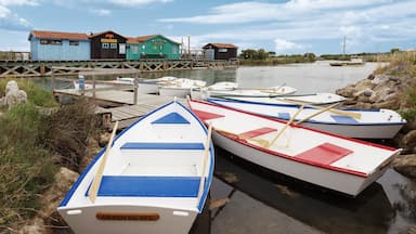 A dock with several small boats, a wooden pier, and buildings with signs like "Restaurant" and "Hotel."