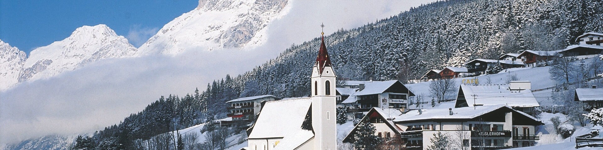 Seefeld in Tirol que inclui montanhas, neve e uma cidade pequena ou vila