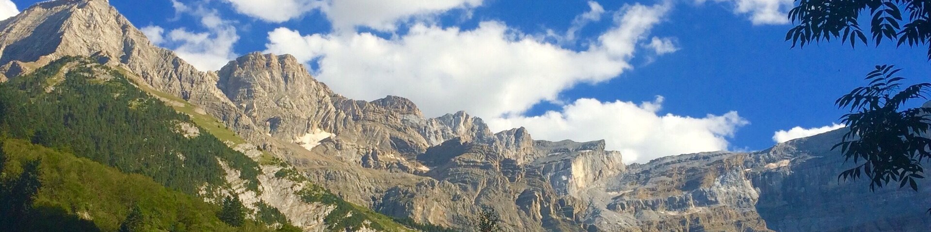 Uma cordilheira com picos rochosos e um céu azul límpido.