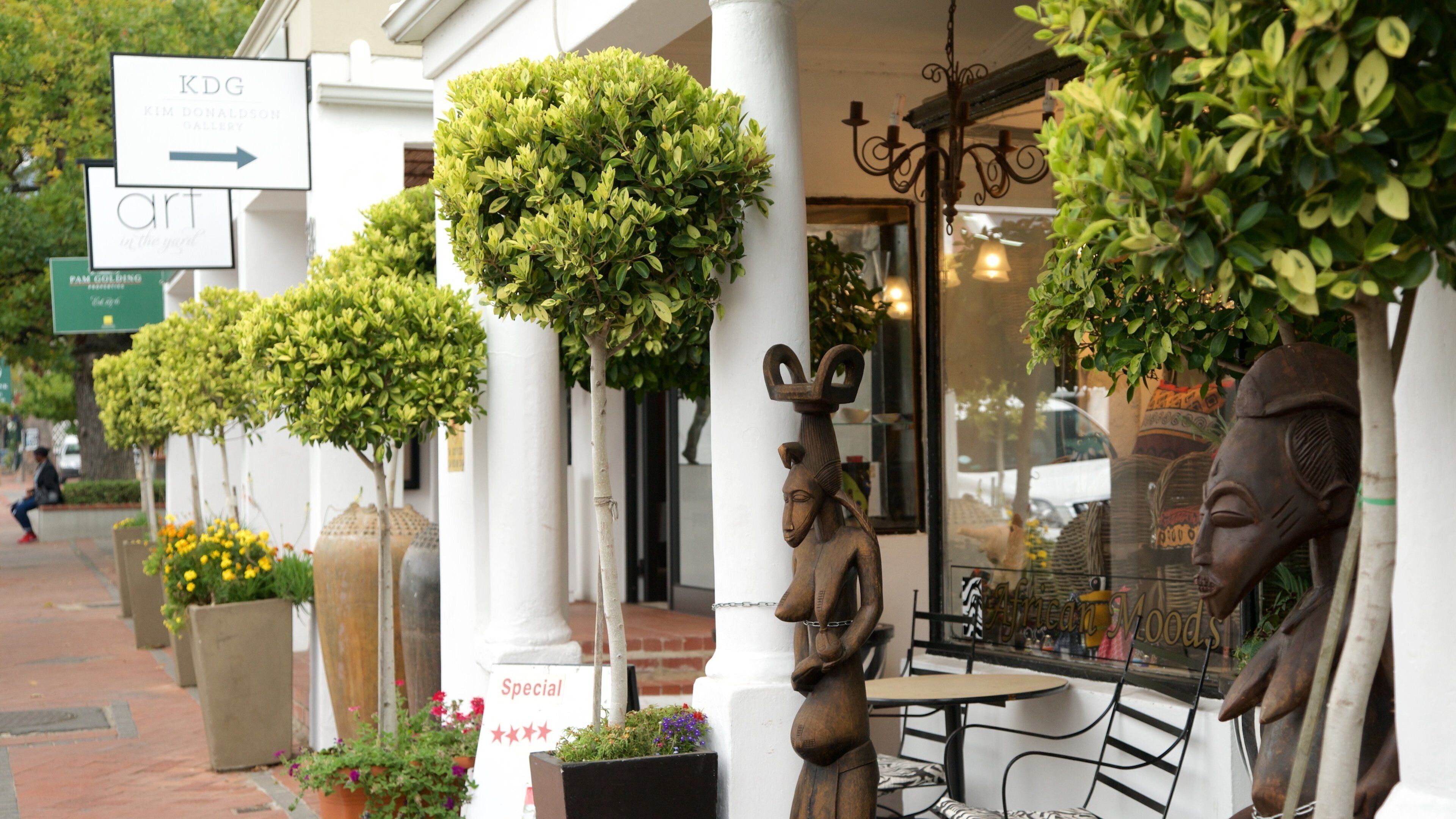 Fachada com arte no jardim, placa indicando Kim Donaldson Gallery e estátua de um homem.
