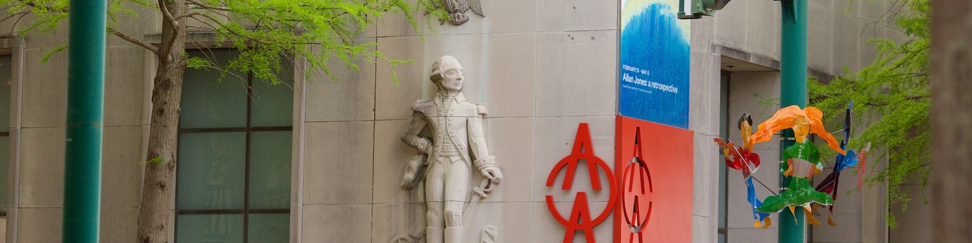 Uma estátua, um semáforo e uma placa de rua.