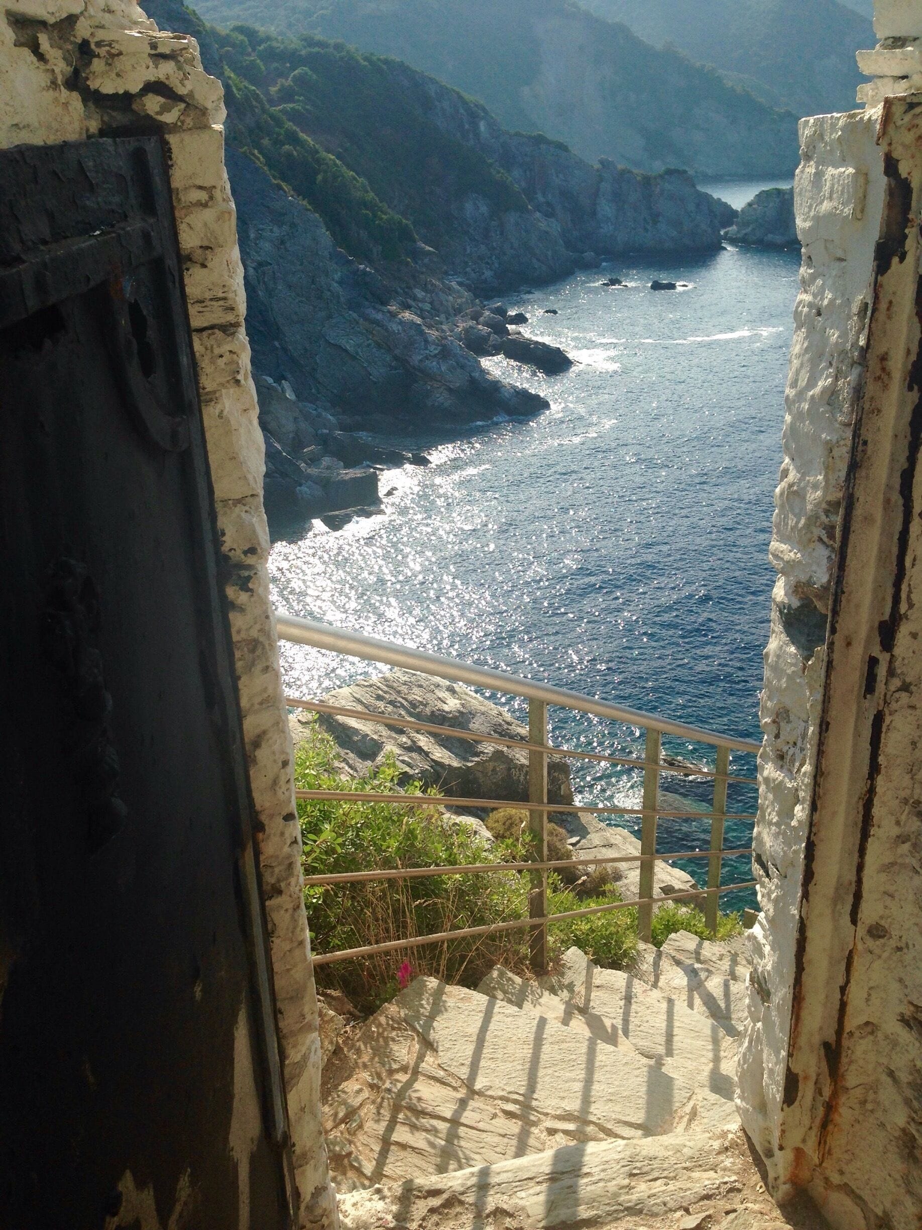 Vista costeira com guarda-corpo, com o mar e falésias à mostra.