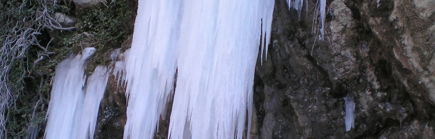 Picos de gelo pendurados em um penhasco rochoso.