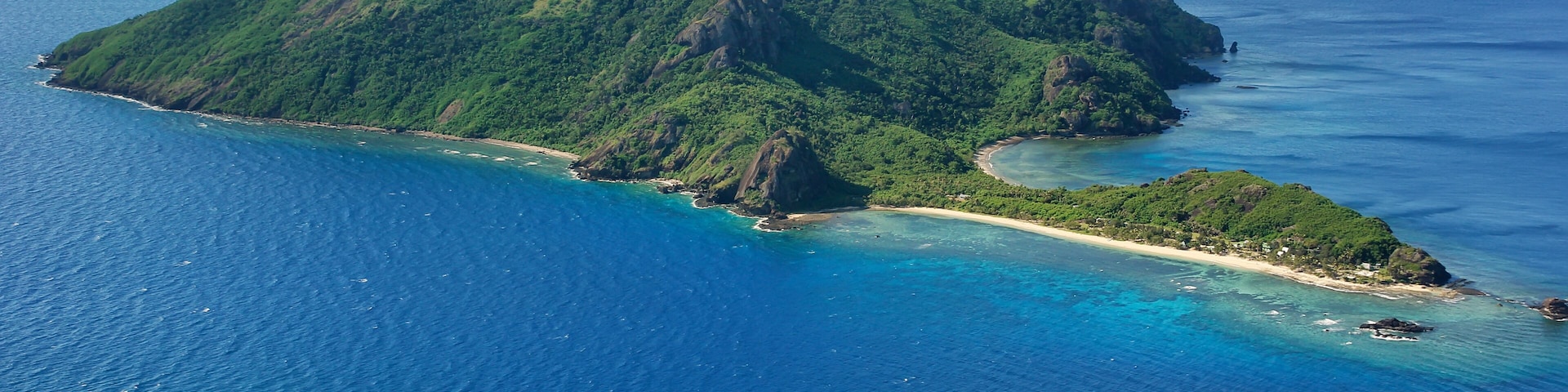 Uma ilha verdejante cercada por águas azul-claras.