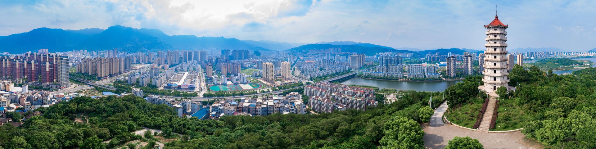 Paisagem urbana com uma pagoda imponente, edifícios altos e um rio.