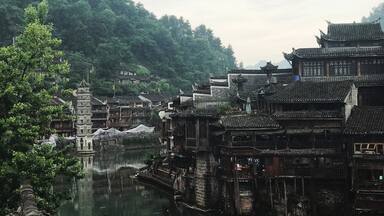 Uma aldeia tradicional chinesa com edifícios de madeira e um rio.