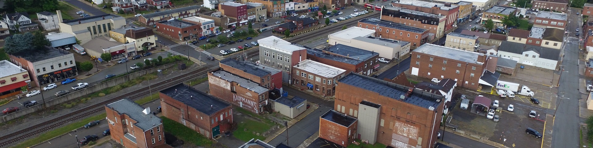 Vista aérea de uma cidade com edifícios residenciais e comerciais, uma linha de trem e um caminhão da FedEx.