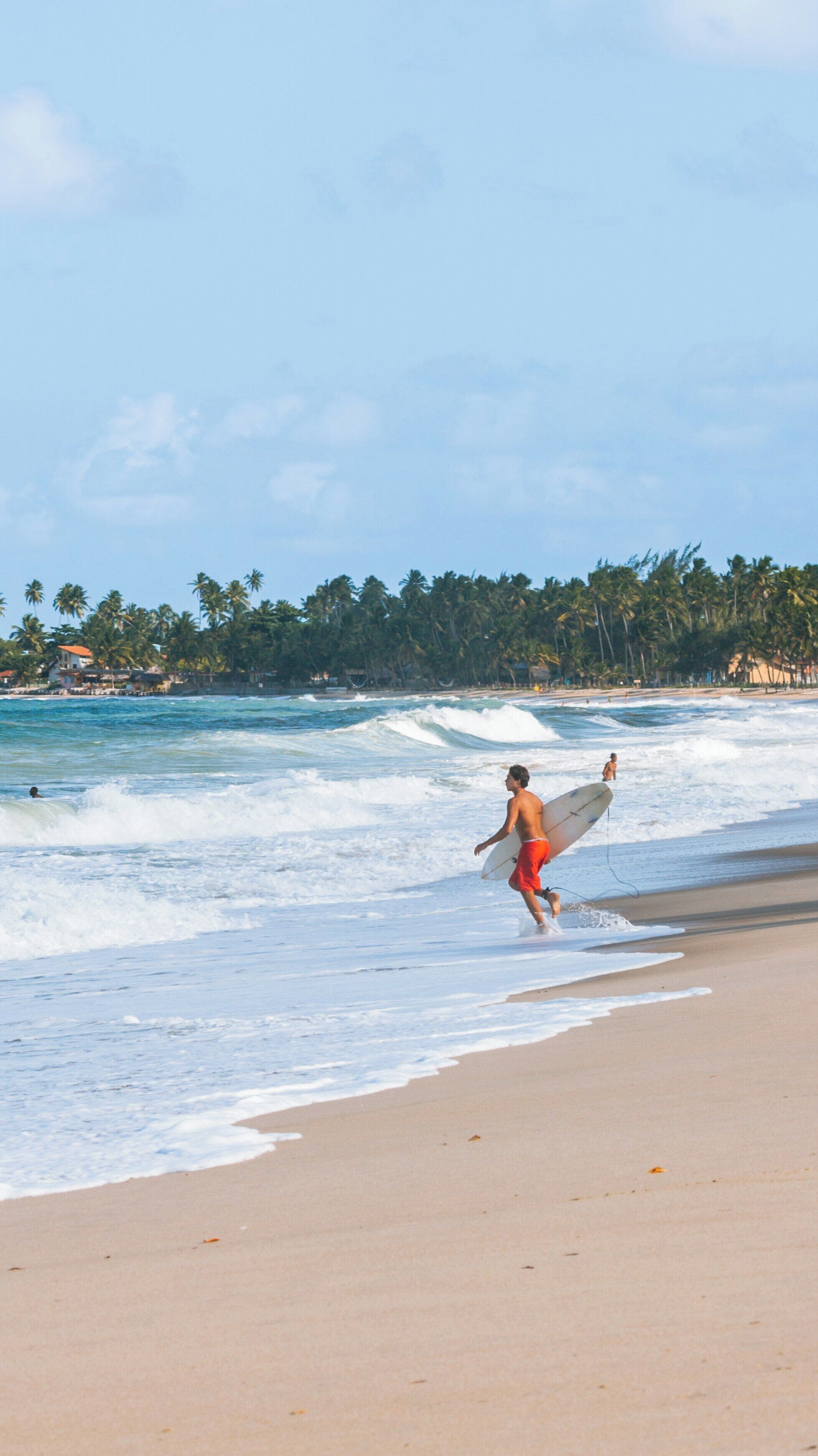 Surfer enjoying the waves at Maracaipe Beach in Porto de Galinhas, Ipojuca, Pernambuco, Brazil on a sunny day