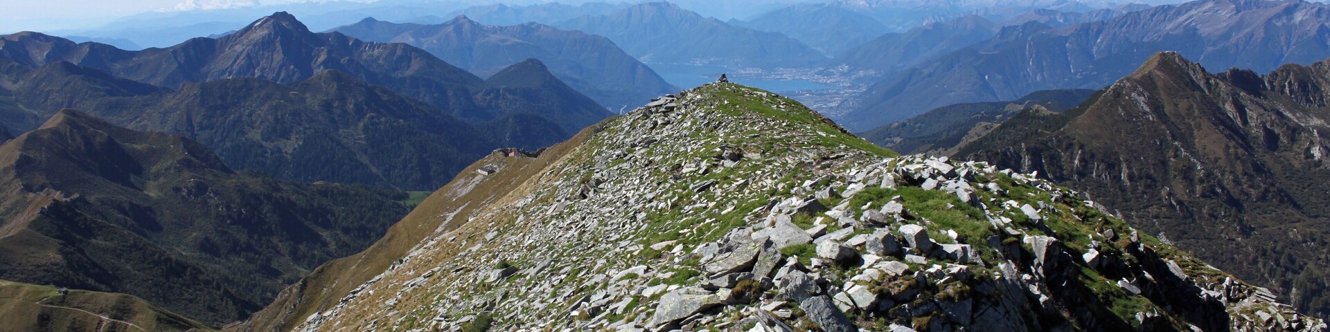 Auf dem Gipfel des Monte Marmontana ( 2316 m.ü.M.) über den genau die Grenze zwischen der Schweiz und Italien verläuft. Hier geht der Blick zum Passo San Jorio (2010 m.ü.M.) (links im Bild) und dann weiter zum Lago Maggiore bis zum mächtigen Monte Rosa.