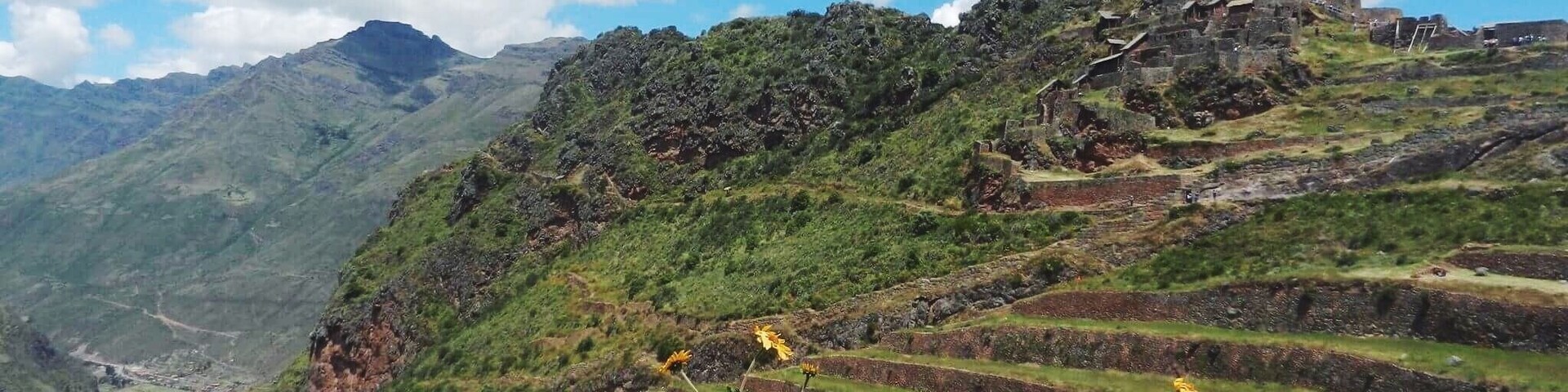 Campos em socalcos, paisagem montanhosa e céu claro.