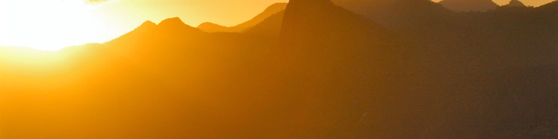 Região Sudeste caracterizando montanhas, uma cidade e um pôr do sol