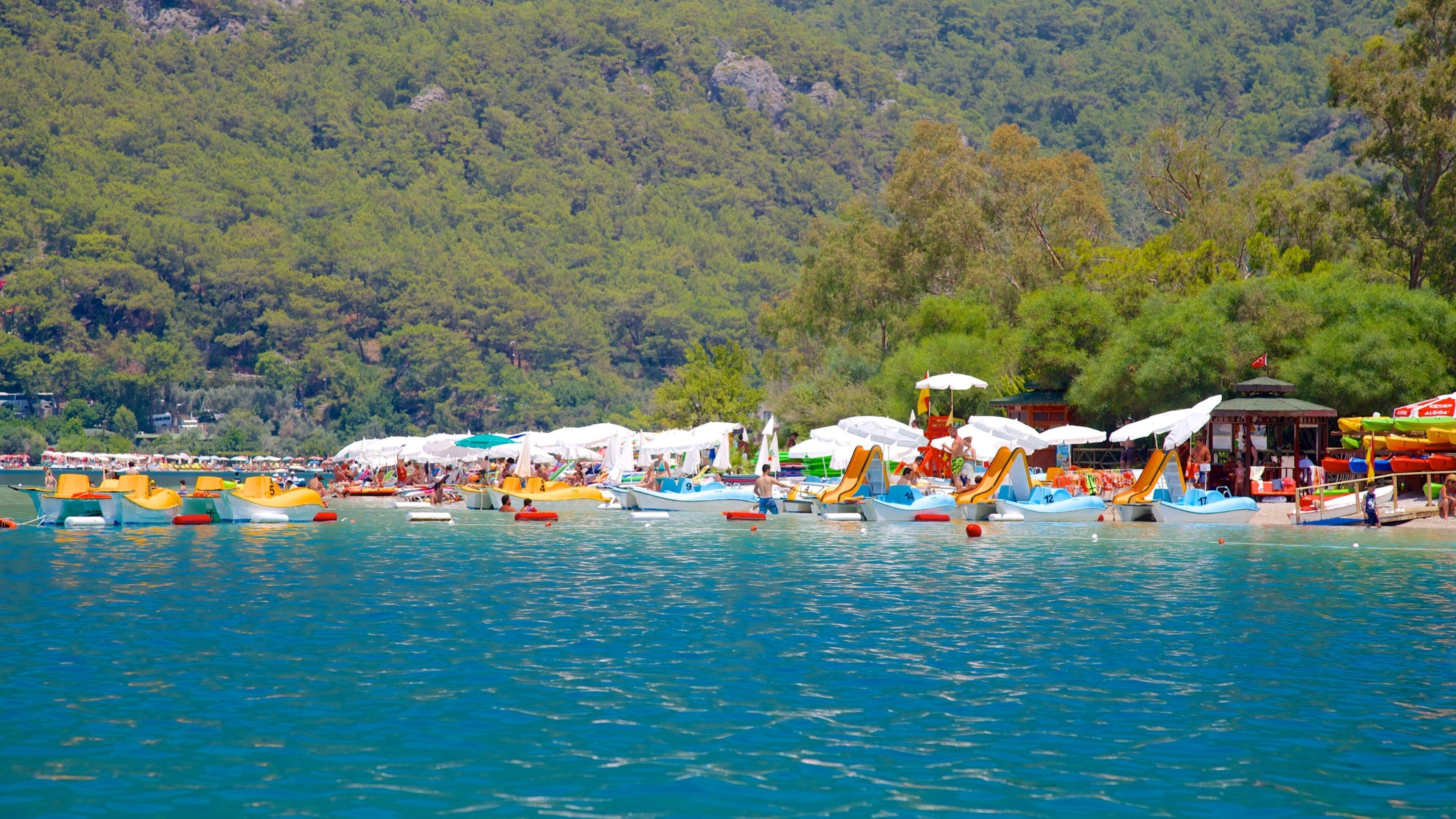 Uma praia com muitos barcos coloridos e guarda-sóis.