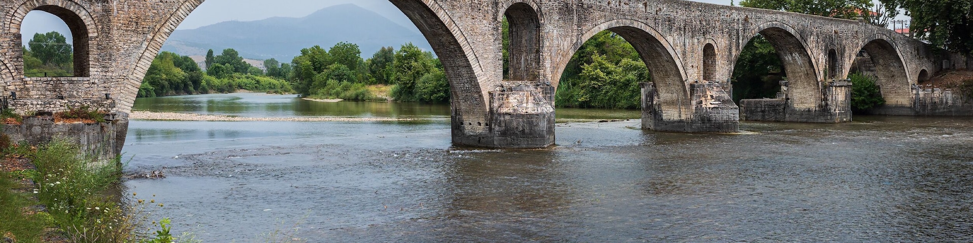 Arta Bridge - A bridge over the Arachos River in the city of Arta. The construction of the bridge dates back to the era of Despotat, but the current appearance by 1602.
According to legend, every day 60 students and 45 craftsmen under the guidance of the chief builder tried to build a bridge, but it fell every night. Finally, a bird with a human voice told the chief builder that in order for the bridge to stand, he had to sacrifice his spouse. When the wife was walled up, she first cursed, but then finished with blessings.