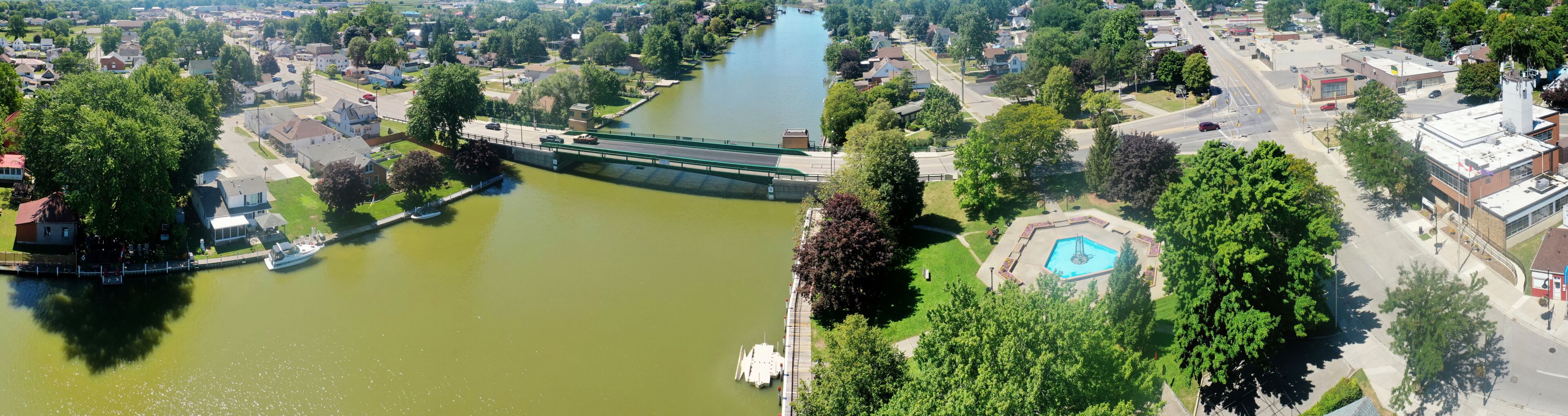 Um rio com uma ponte, uma piscina e vegetação ao redor.