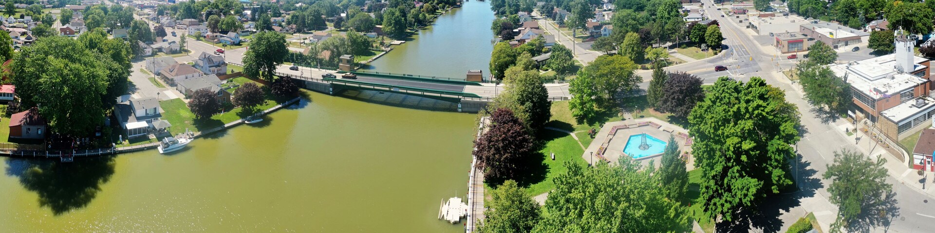 Um rio com uma ponte, uma piscina e vegetação ao redor.