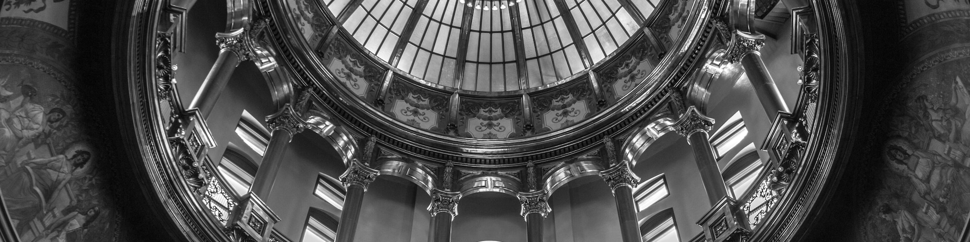 Uma cúpula imponente e ricamente decorada, com padrões intrincados e uma clarabóia central.