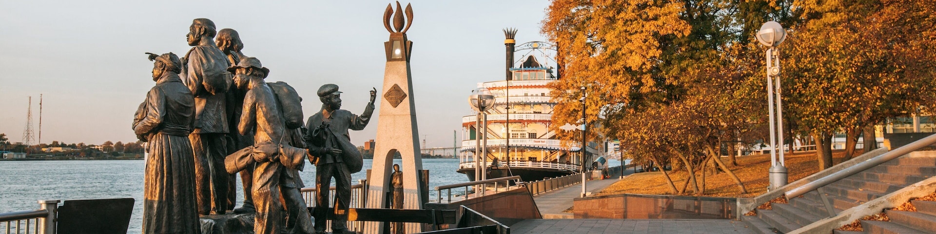 Downtown Detroit which includes a statue or sculpture, a park and a river or creek