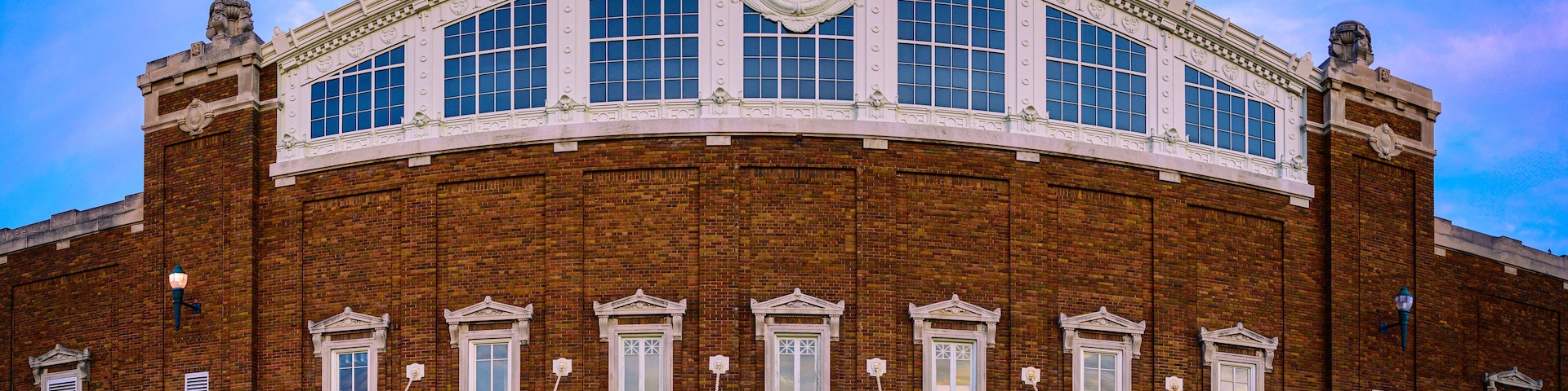 Um edifício grande de tijolos, com fachada curva, janelas amplas e detalhes decorativos.
