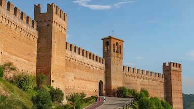 Um grande castelo de tijolos com várias torres e uma torre central com uma cruz no topo.
