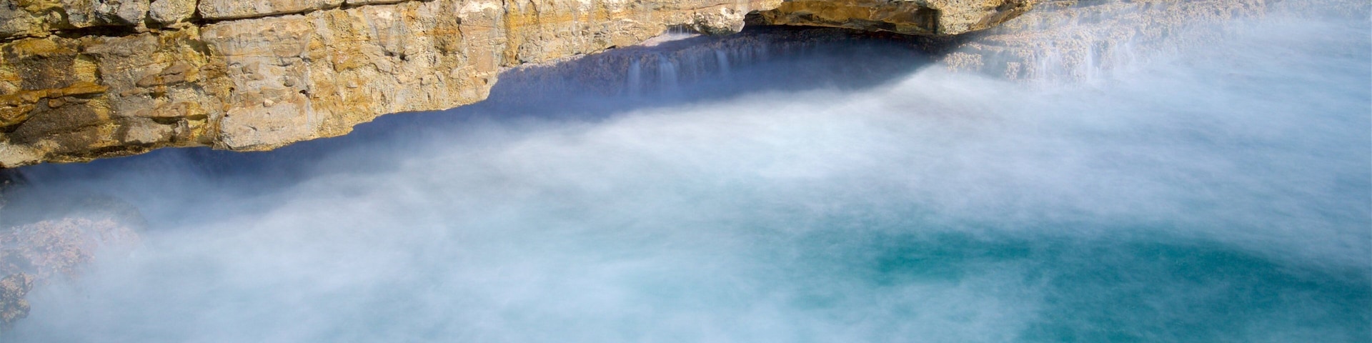 Devil\'s Bridge mostrando surfe, litoral acidentado e paisagens litorâneas