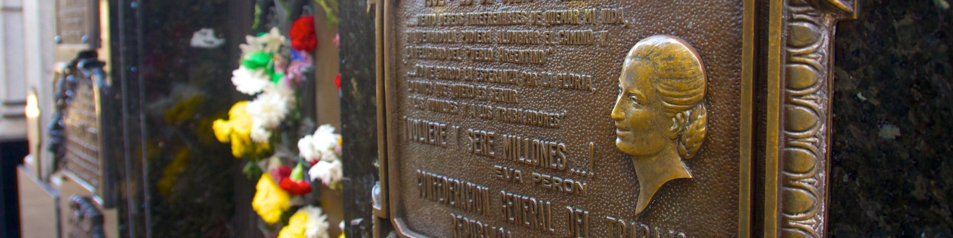 Uma placa comemorativa com texto gravado e um busto.