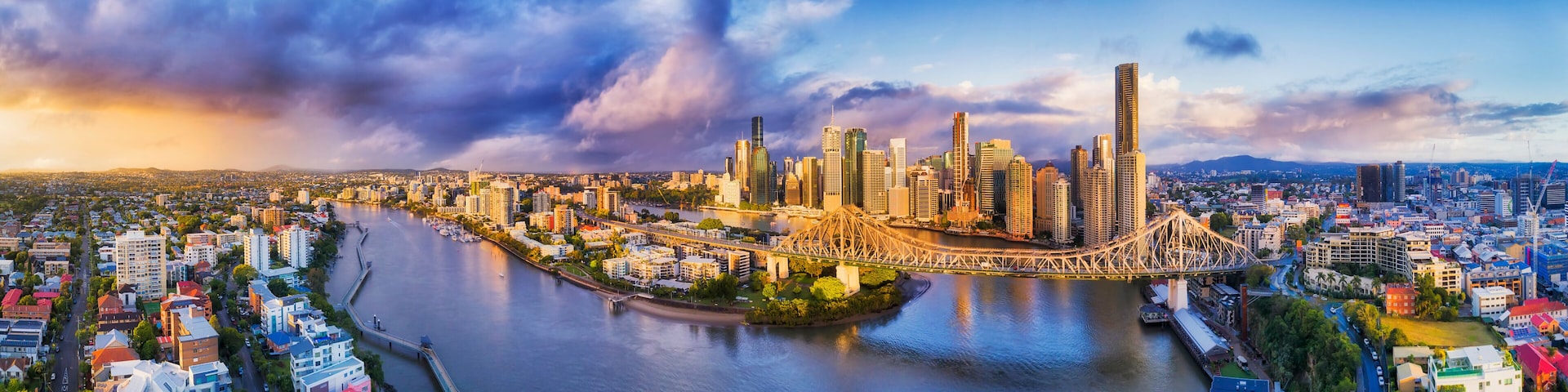 Paisagem urbana com rio, uma ponte imponente e edifícios altos.