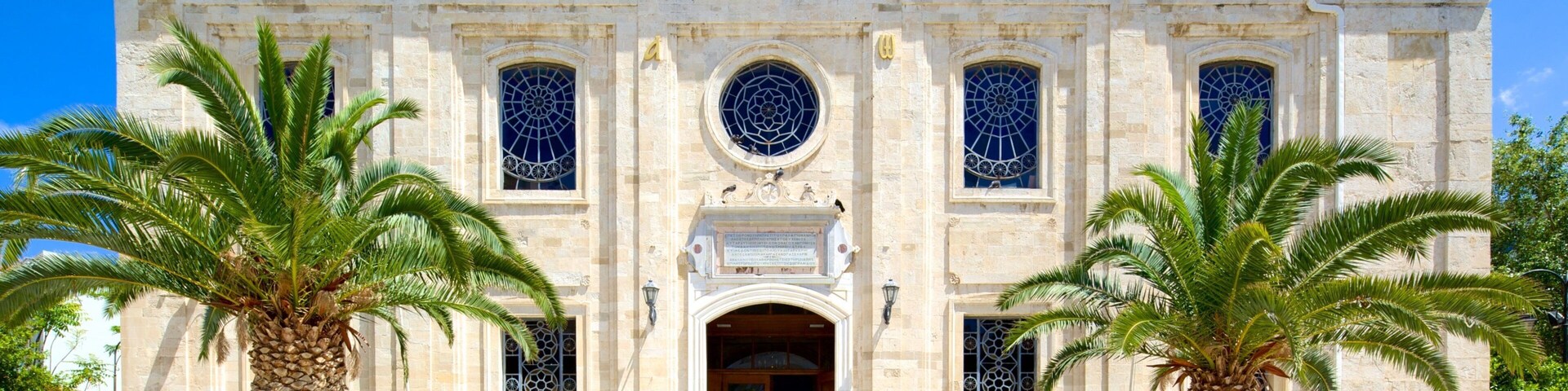 Um edifício histórico com janelas ornamentadas e um arco central.