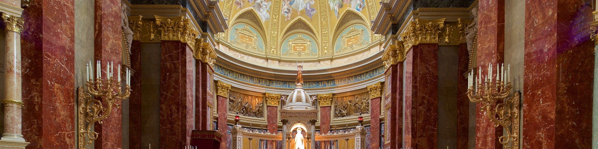 Interior de igreja ornamentado, com colunas de mármore, altar central e teto abobadado com afrescos.