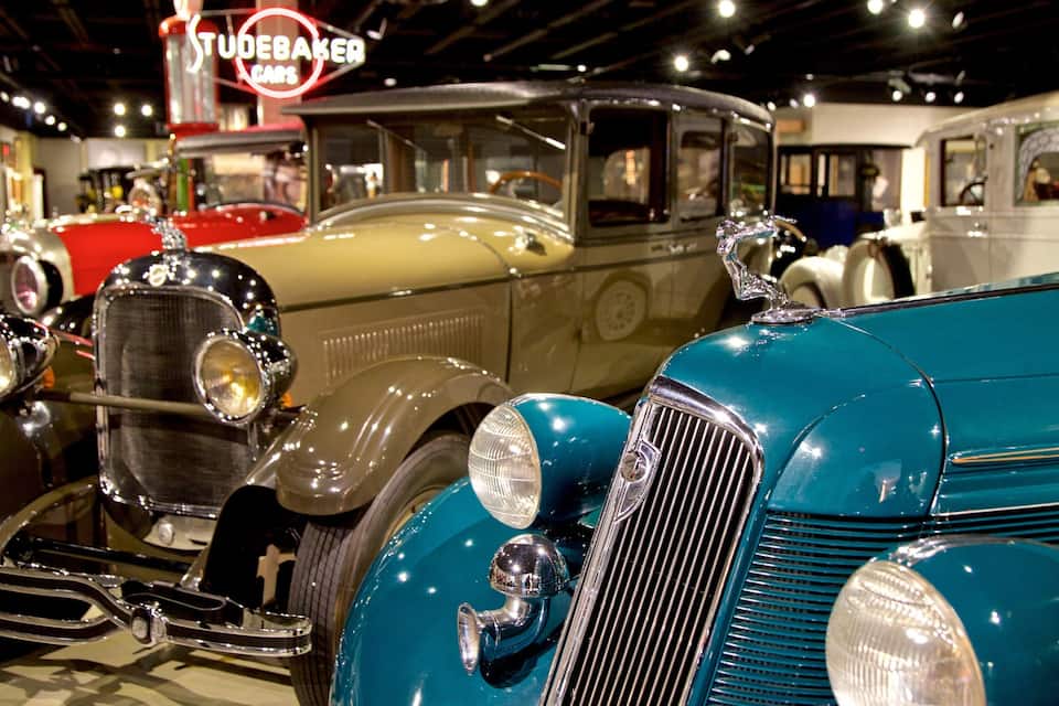 Carros antigos em exposição num museu.