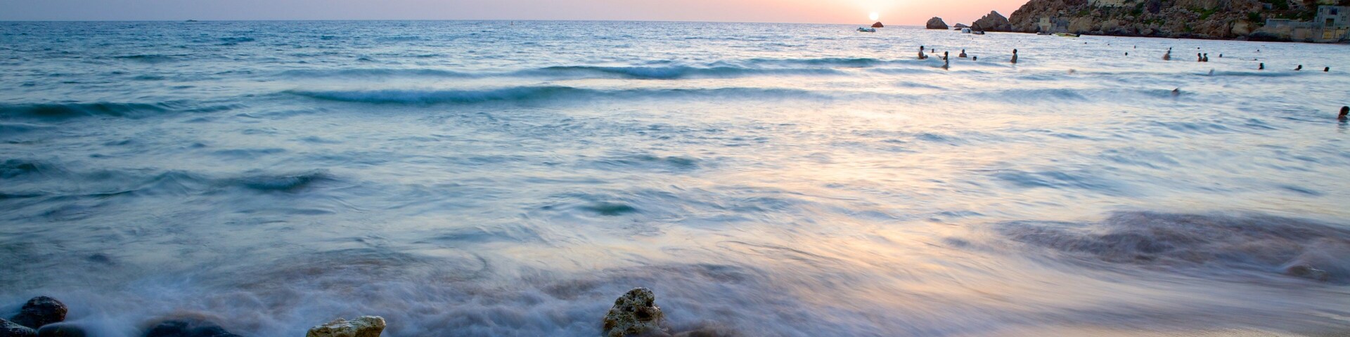 Golden Sands Beach which includes a sunset and rugged coastline