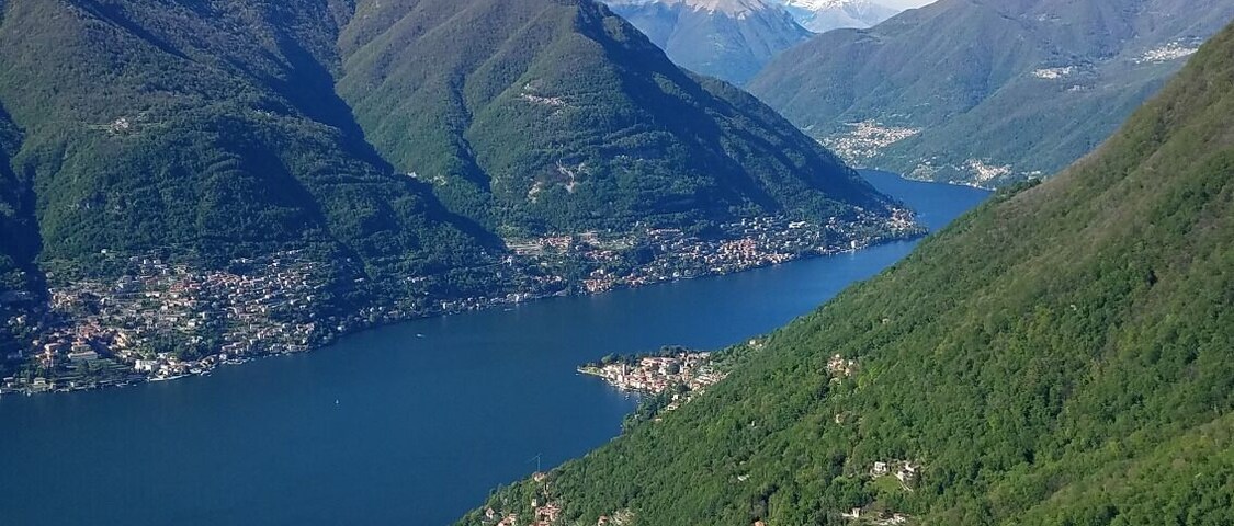 Paisagem montanhosa com um lago e uma cidade aninhada no vale.