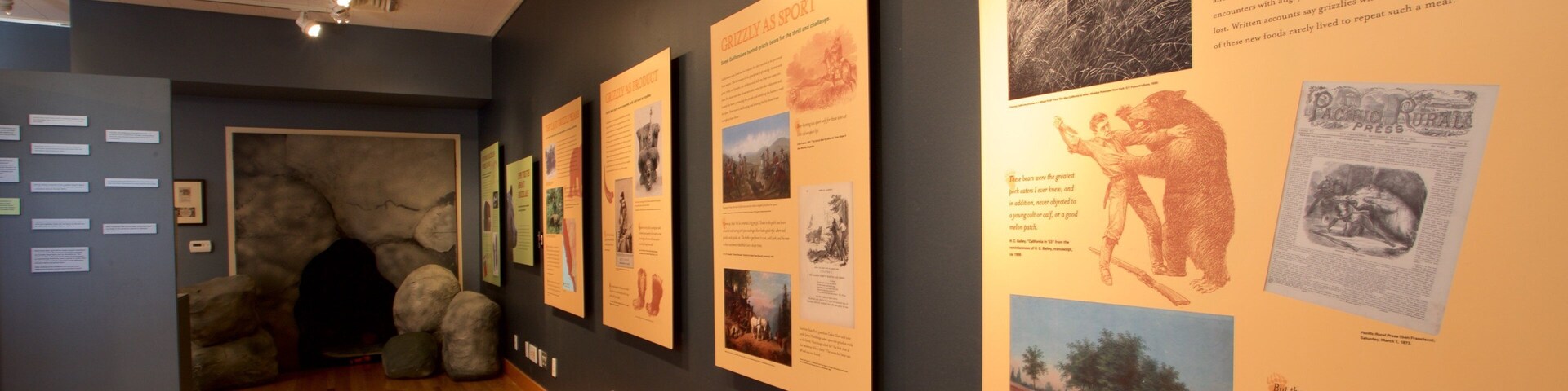 Exposição de museu com cartazes educativos sobre ursos-grizzly e agricultura.